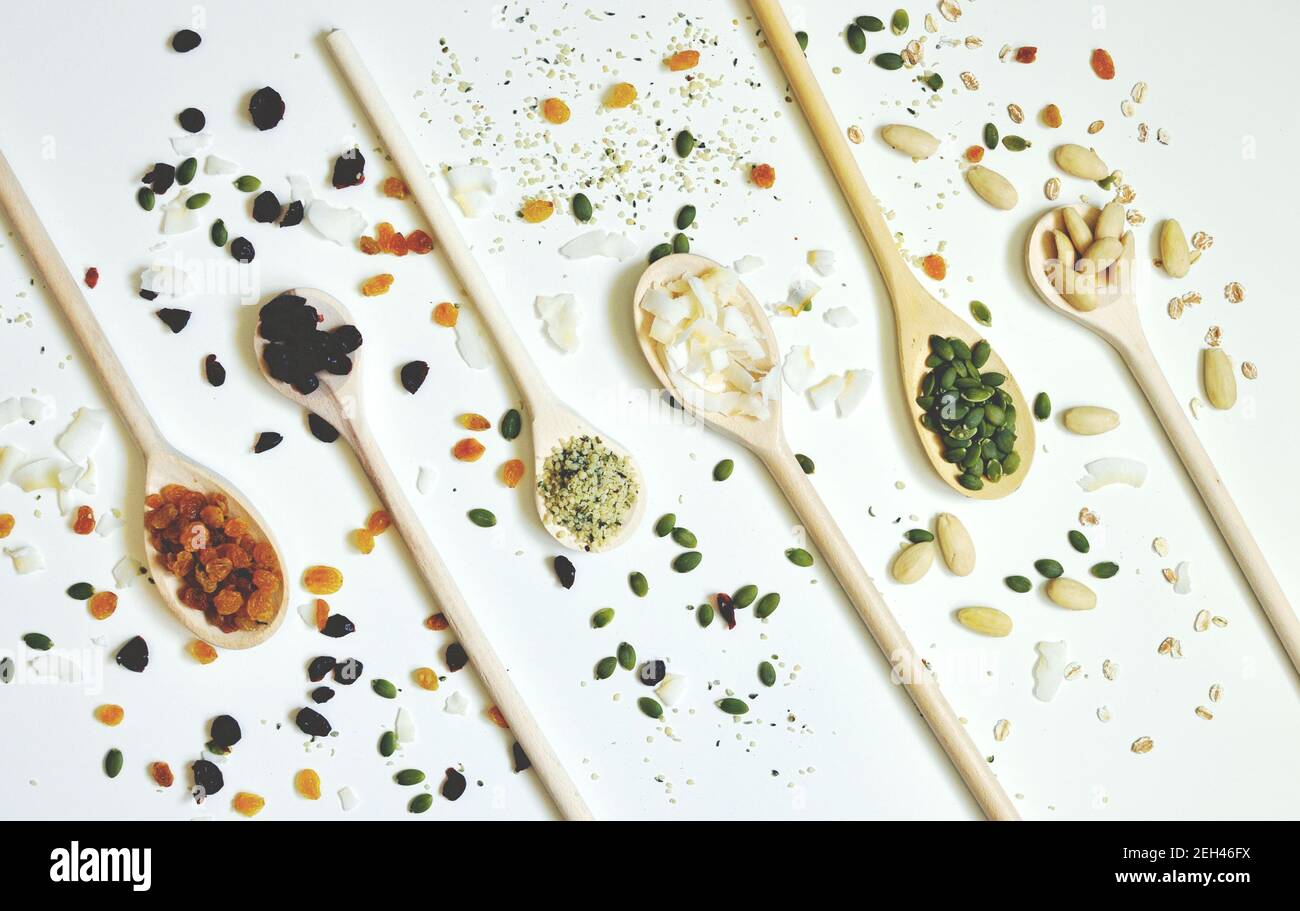 Concept of wooden spoons full of seeds and cereals on white background ...