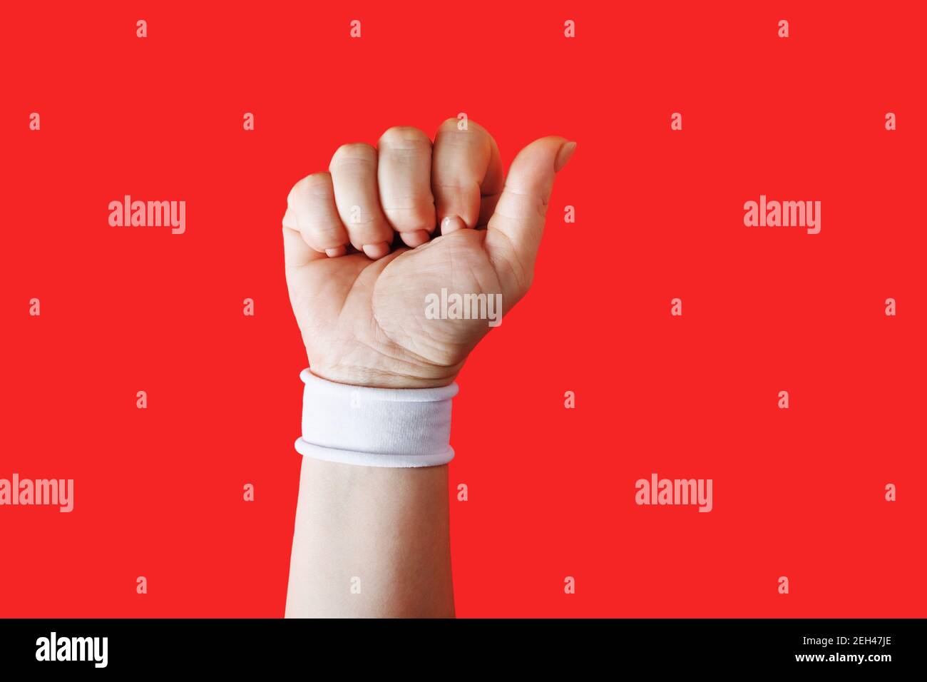 Clenched fist female hand on red backgroung Stock Photo - Alamy