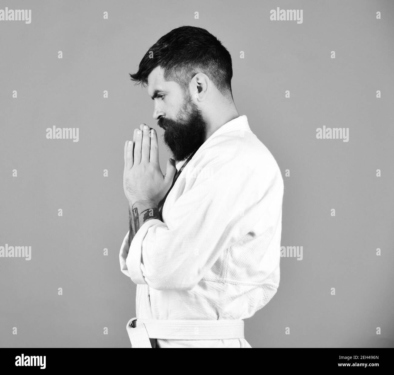 Judo master holds hands together in traditional greeting or prayer ...