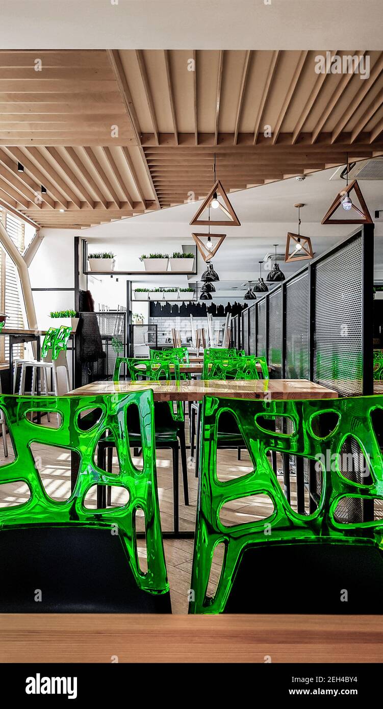 Cafeteria, no people dining room with wooden tables and green chairs ...