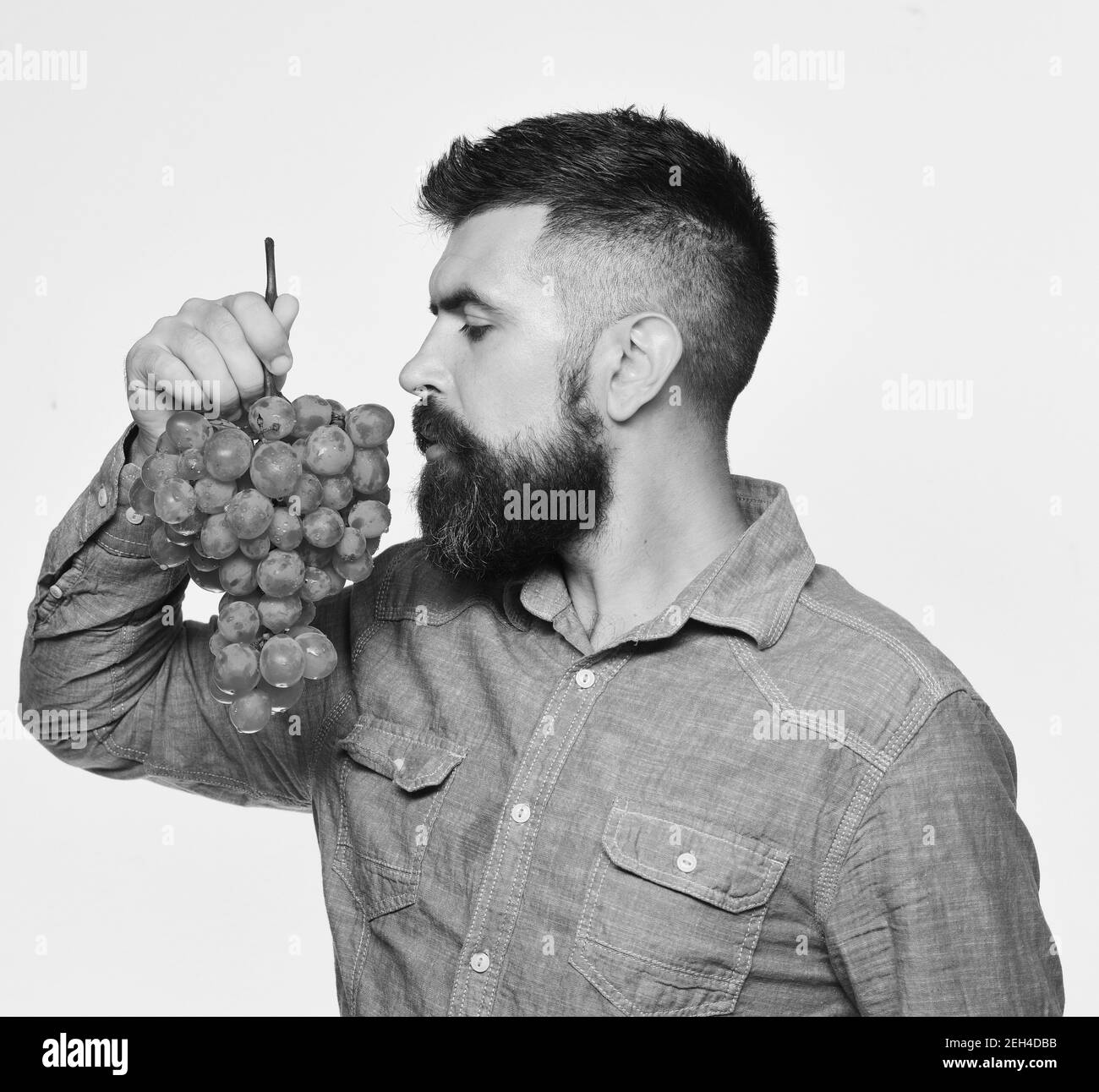 Viticulture and gardening concept. Winegrower with dreamy face smells ...