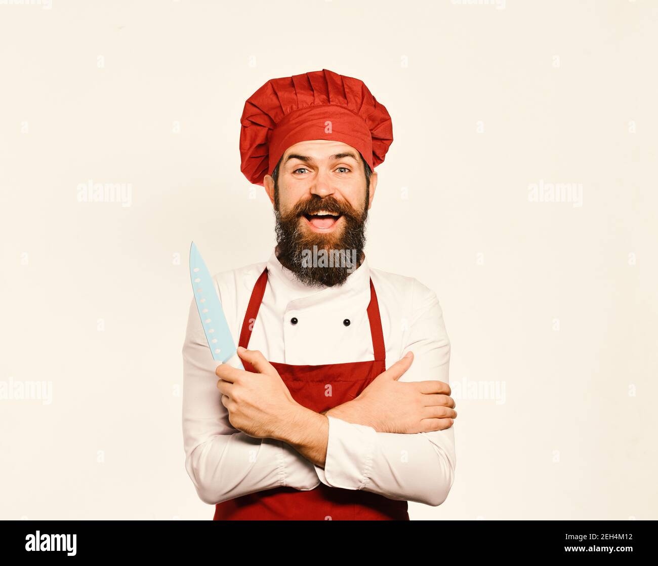Chef with arms crossed holds sharp blue knife. Cook with happy face in ...
