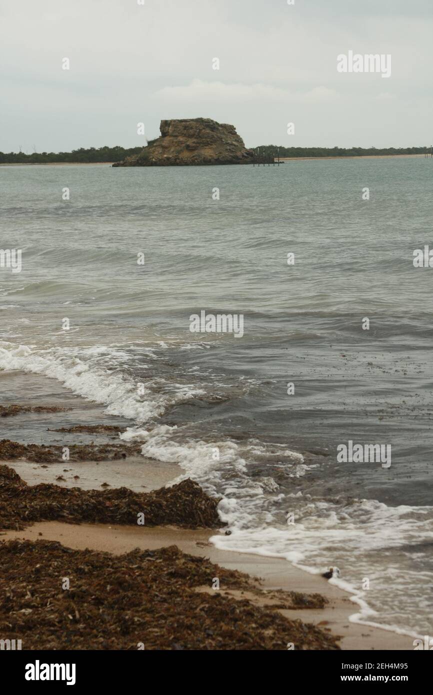 beach with a big rock in the water Stock Photo - Alamy