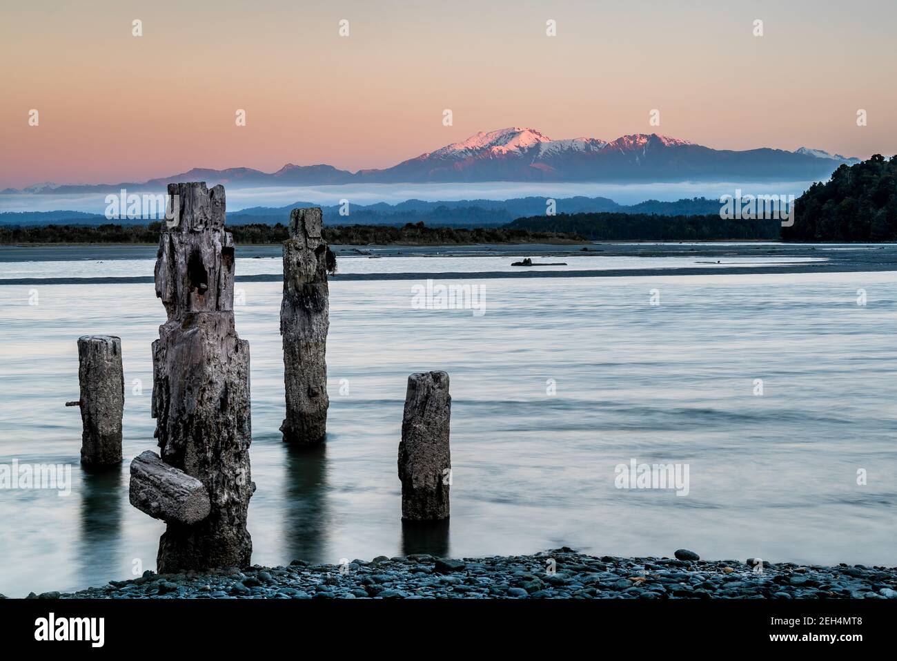 Long Exposure sunrise with mountain background and dilapidated old dock ...