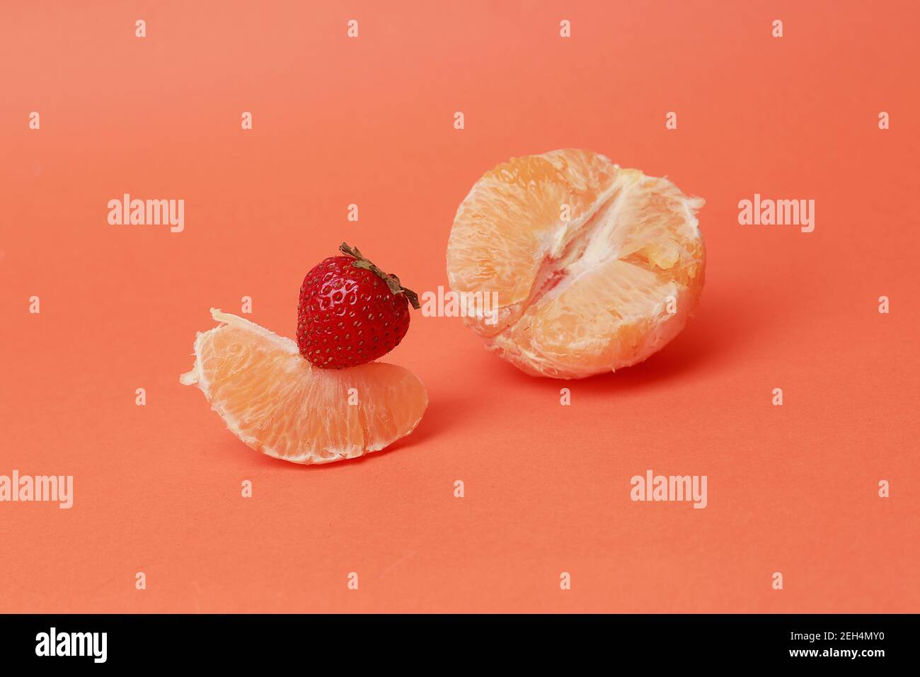 orange and strawberry on a color block background Stock Photo - Alamy