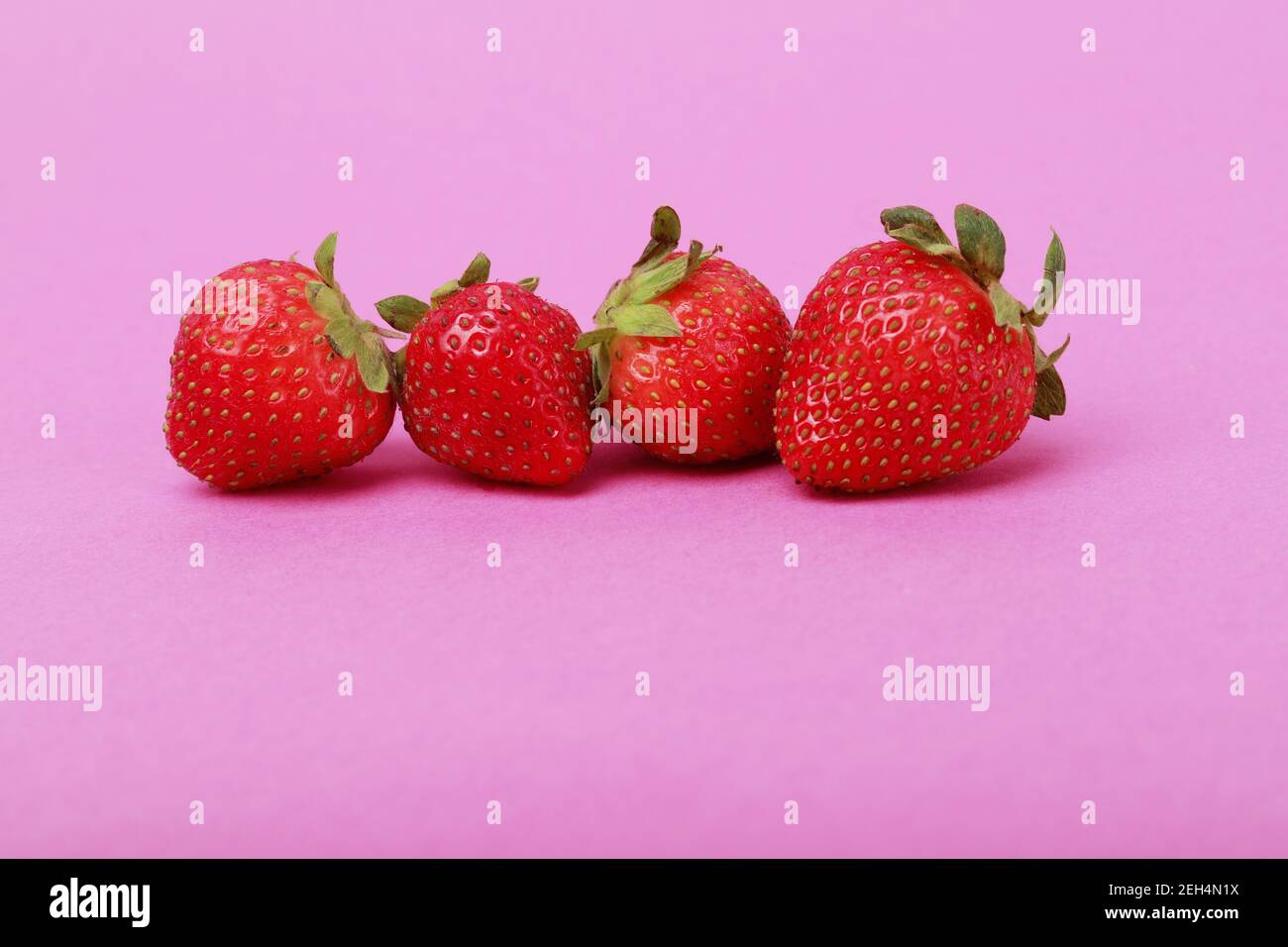 group of strawberries on a pastel background Stock Photo - Alamy