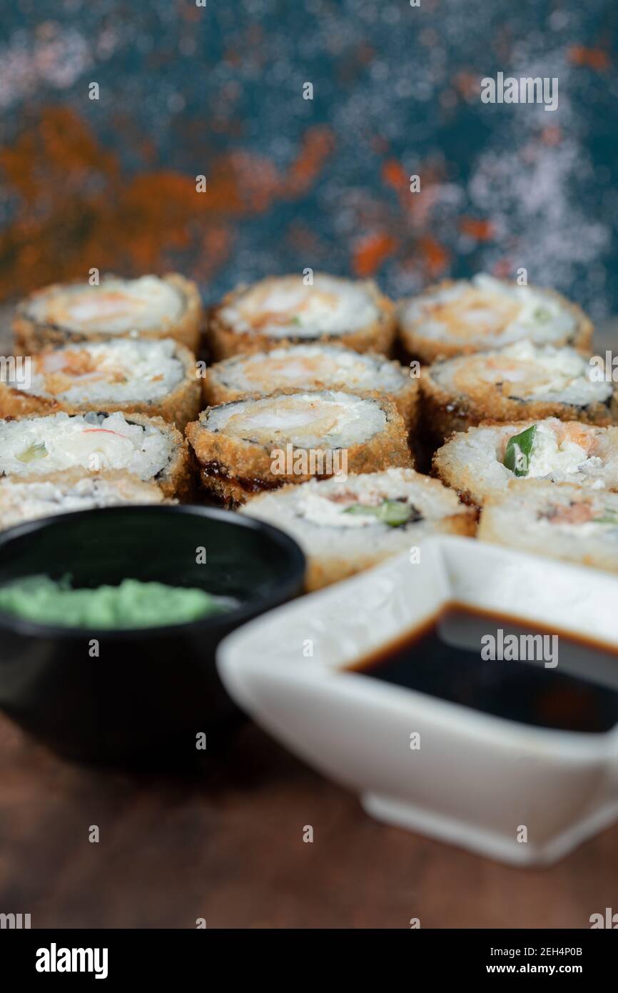 Hot sushi rolls on a wooden board with soy sauce and wasabi Stock Photo ...