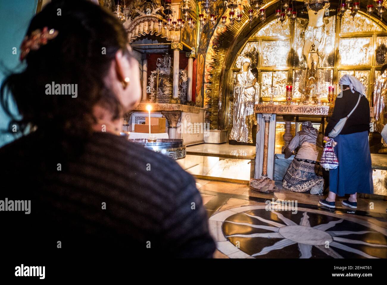 Pilgrims prostrate themselves in the Calvary Chapel, which corresponds ...