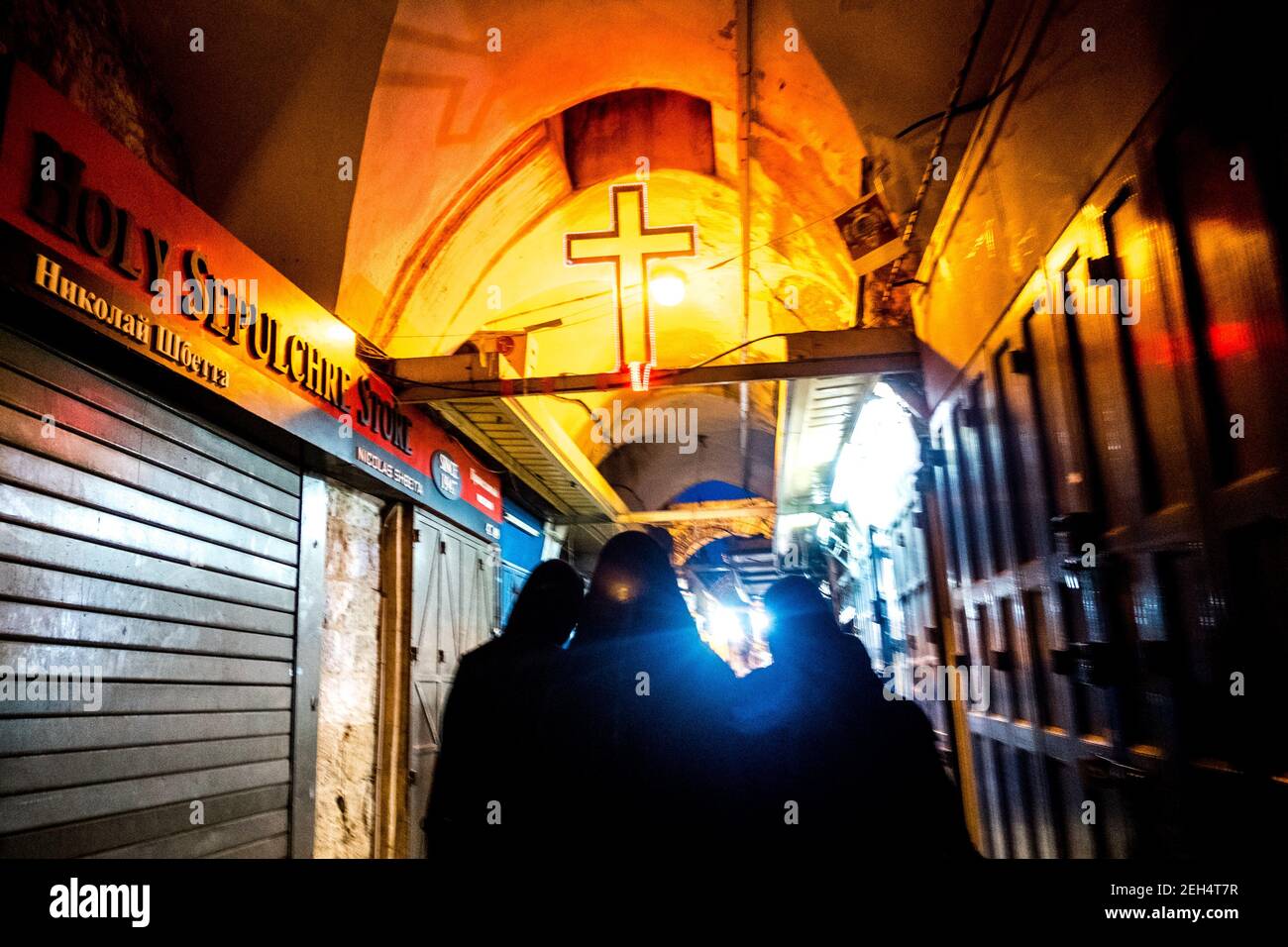 Three Muslim women pass under a cross in an alleyway in Jerusalem's Old ...