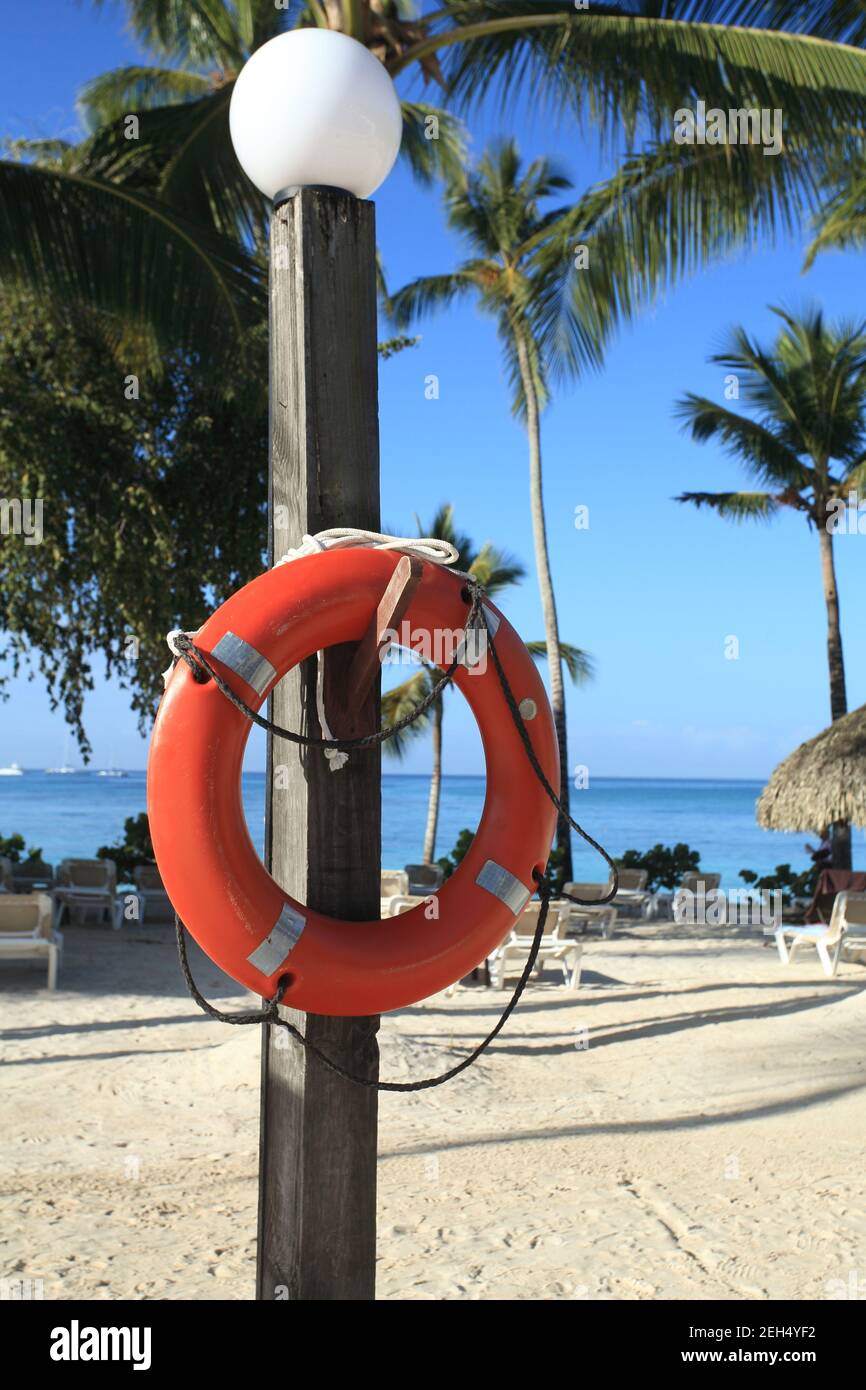 Red life ring attached on a pole on the beach, Bayahibe, Dominican ...