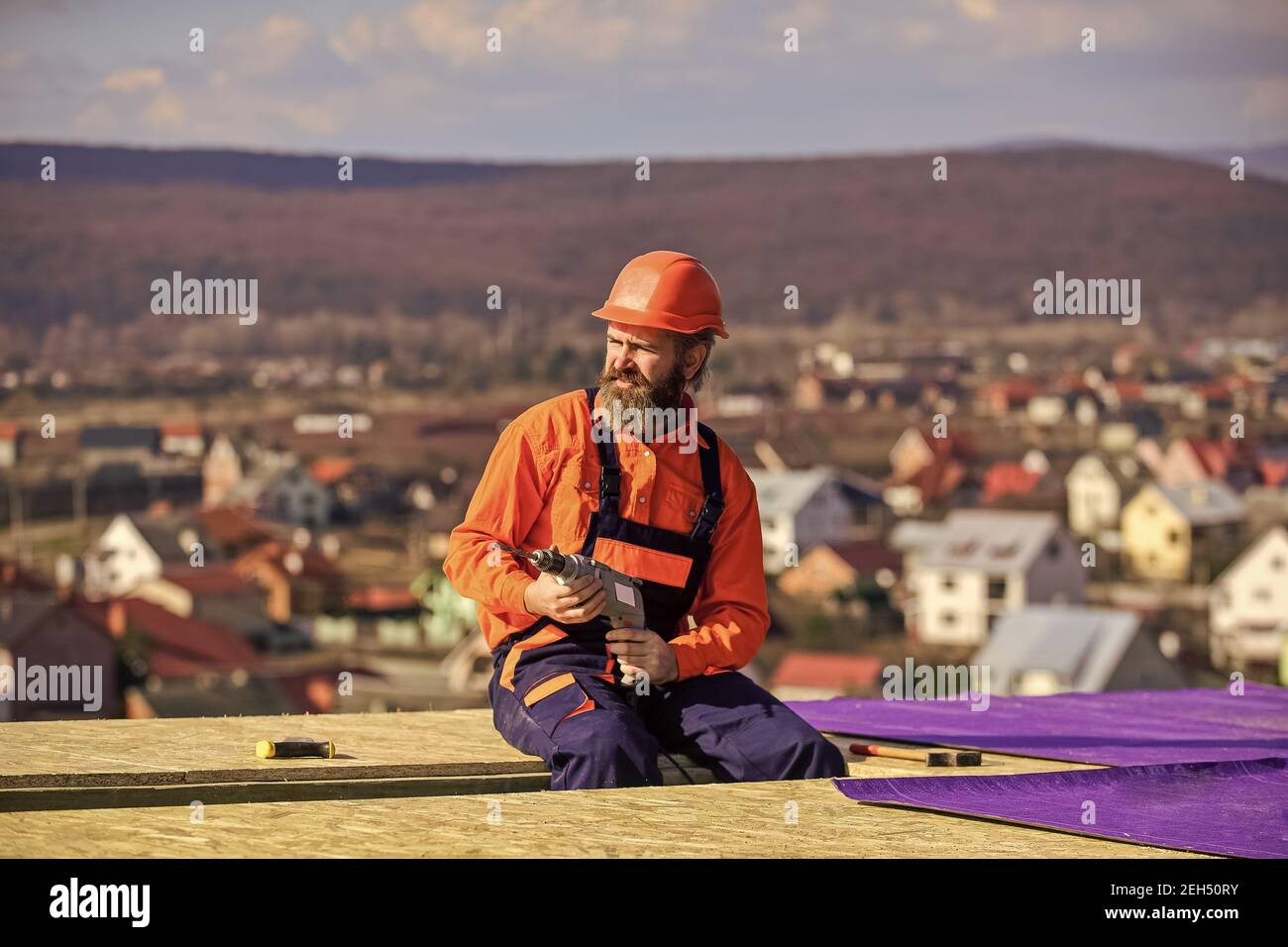 Roofer constructing roof. Man roofing surface. Install partially ...