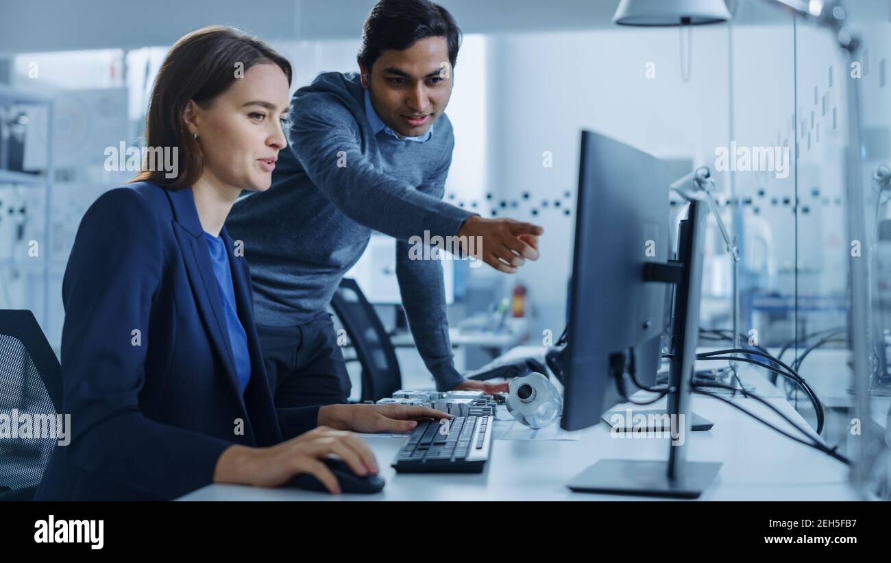 Modern Factory Office: Male Project Supervisor Talks to a Female ...