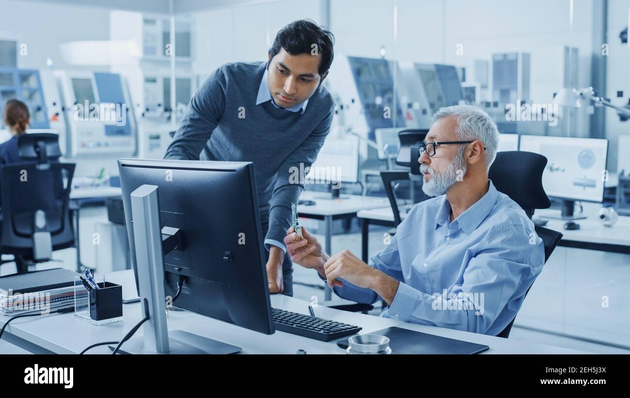 Modern Factory Office: Indian Project Manager Talks to Caucasian Senior ...