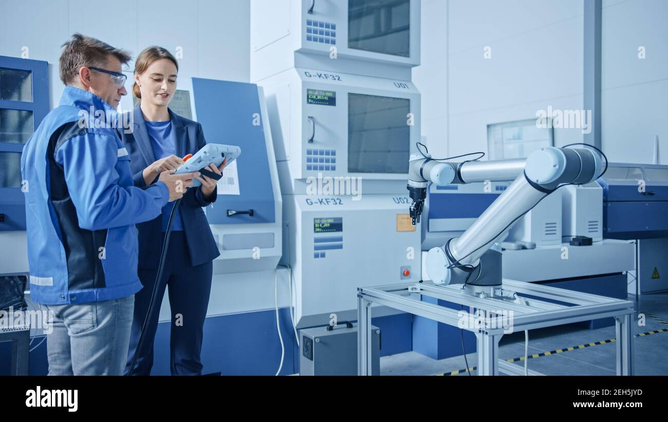 Modern Factory: Female Project Manager and Male Engineer Standing ...