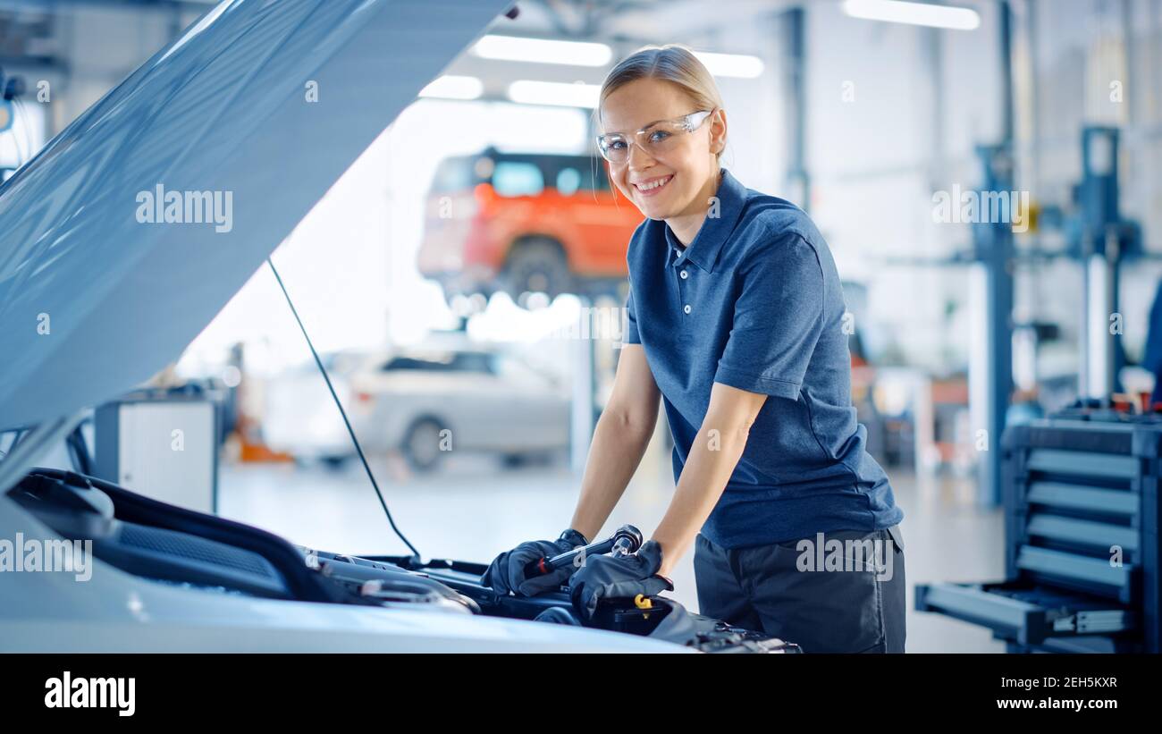 Beautiful Empowering Female Car Mechanic is Posing in a Car Service ...