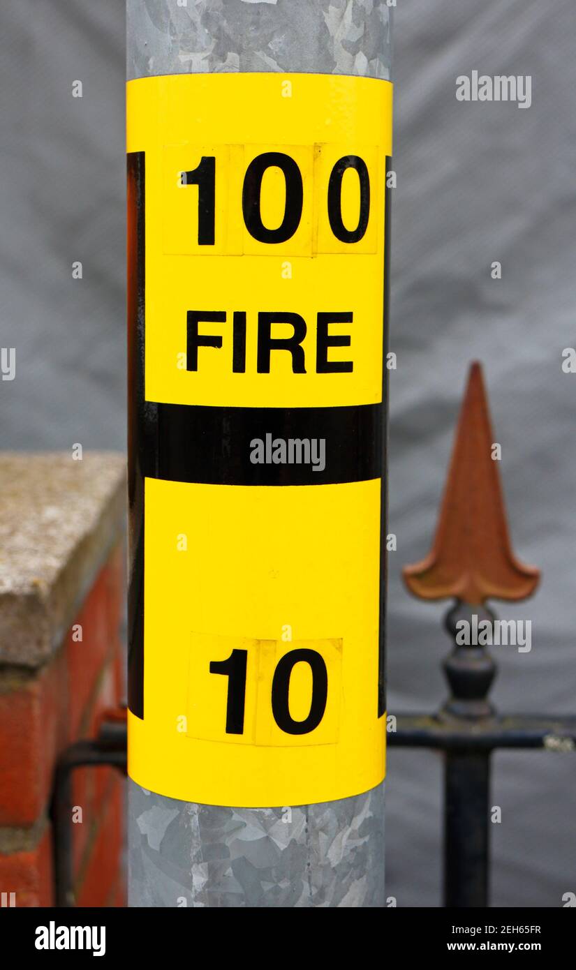 A fire hydrant location sign on a street lamp post in a residential ...