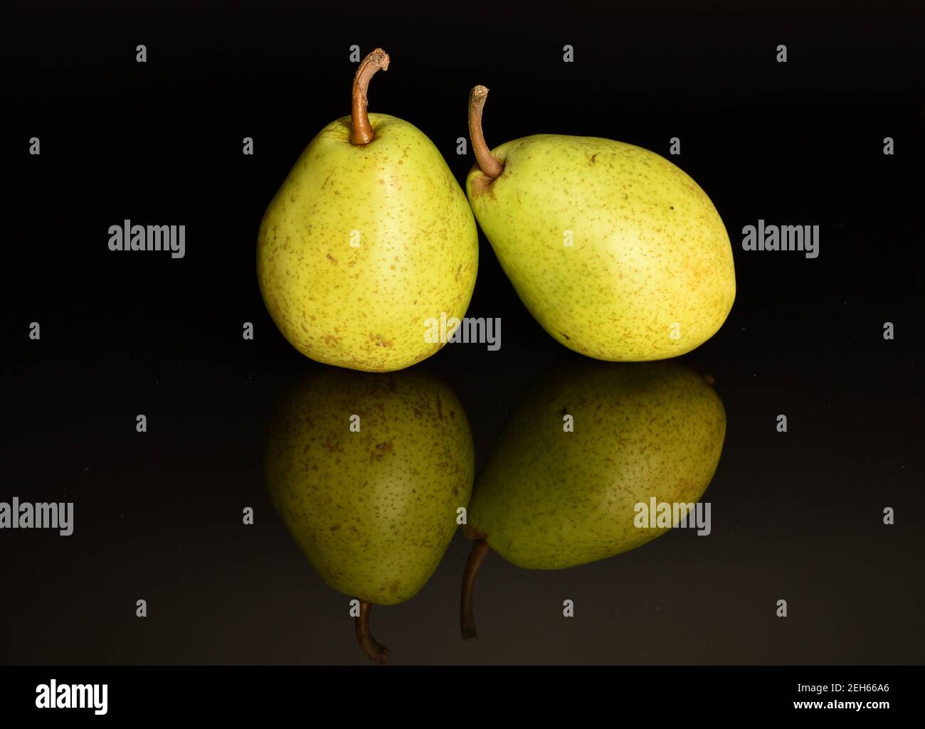 Two whole ripe juicy tasty Lucas pears on a black background Stock ...