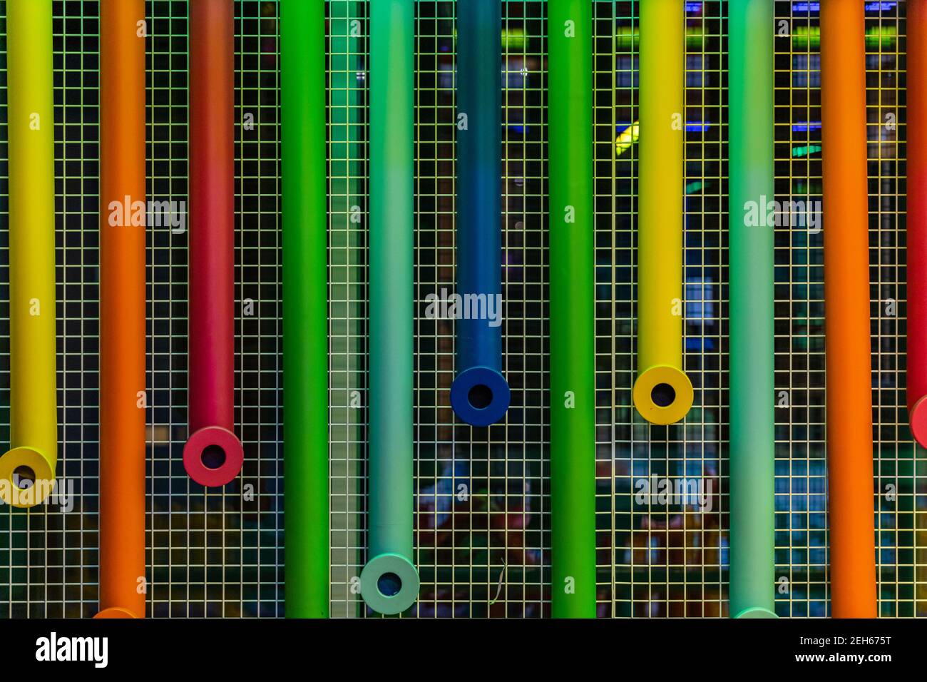 Colorful plastic pipes hanged on metal net Stock Photo - Alamy