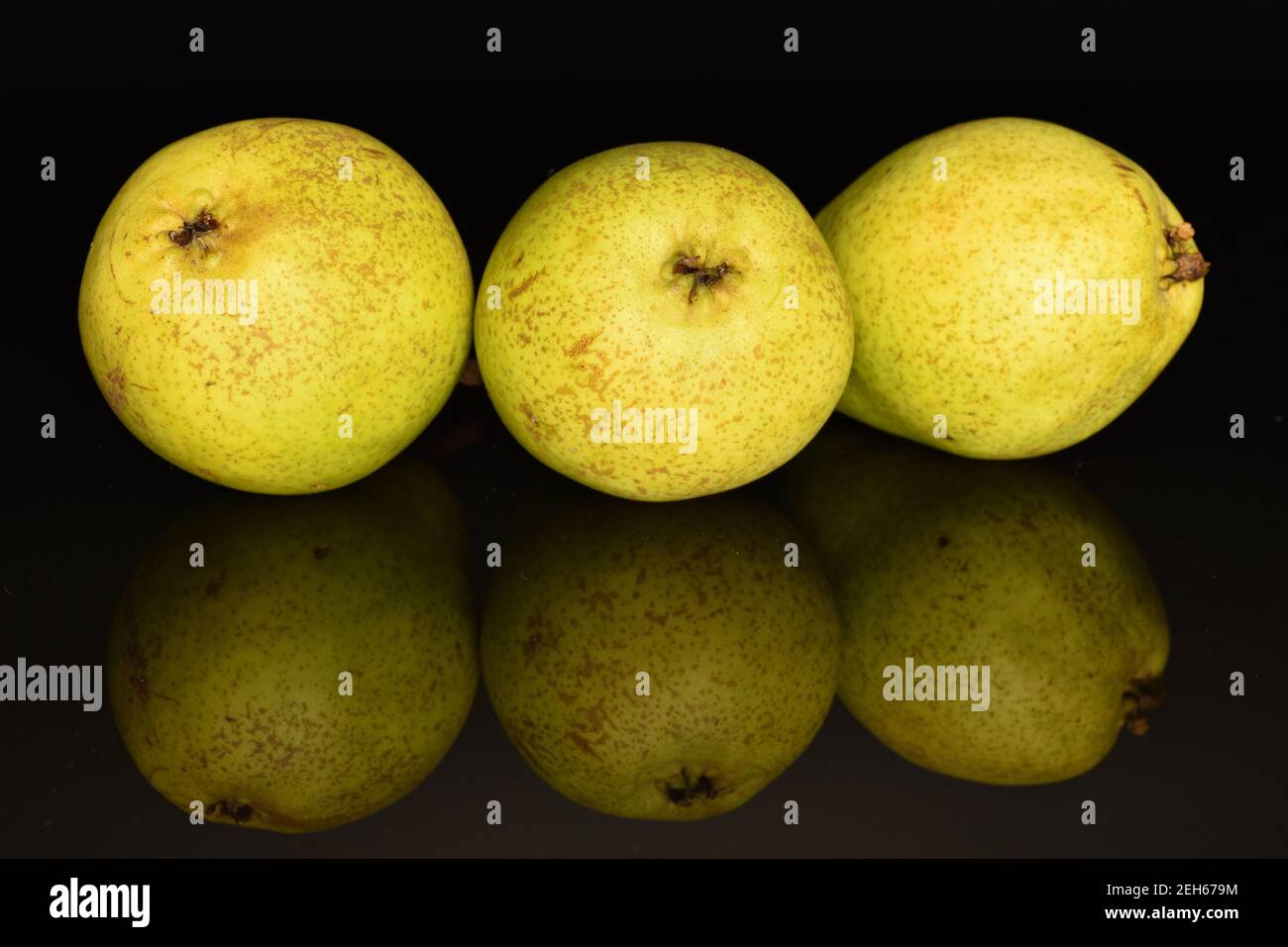 A few whole bright green ripe sweet organic Lucas pears on a black ...