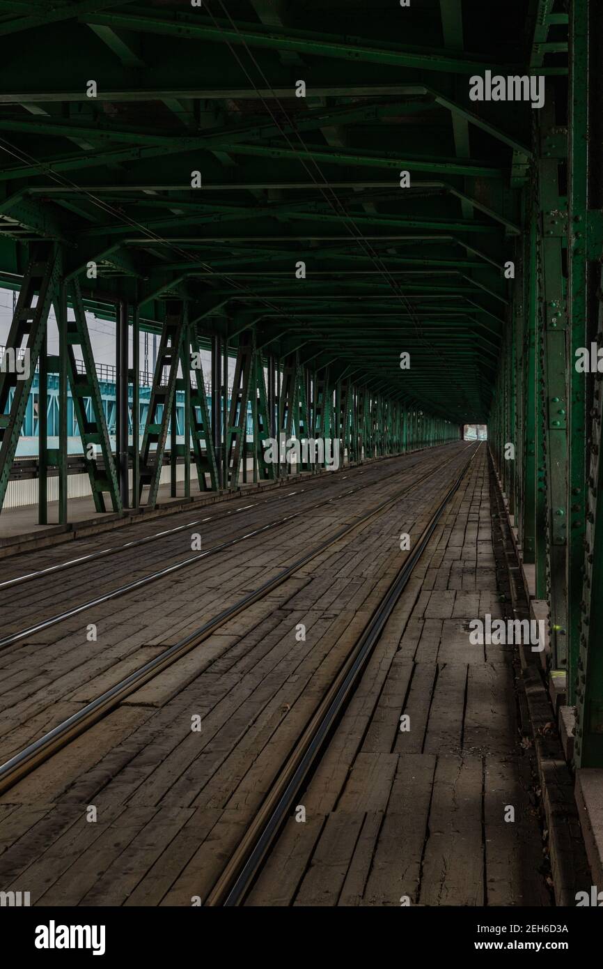 Long wooden and metal bridge with tram rails and green construction ...