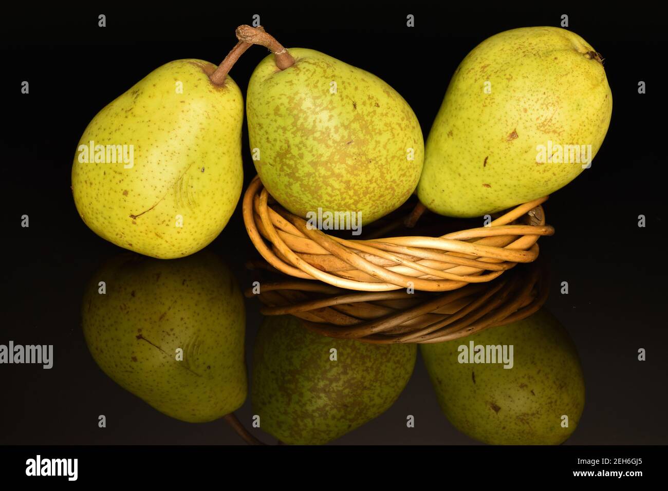 Three whole ripe juicy tasty Lucas pears lie with a wreath of wicker ...