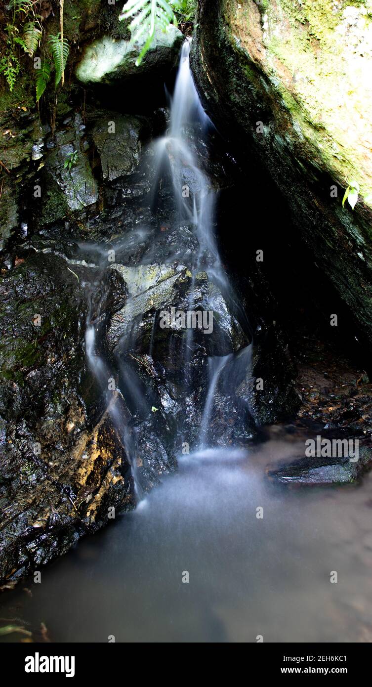Beautiful scene of the waterfall flowing through rocks into a lake in ...