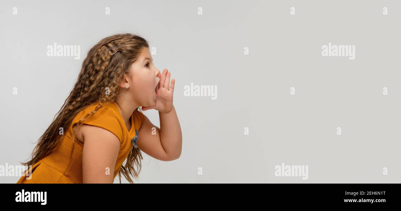 Shouting. Happy, smiley little caucasian girl on white studio ...