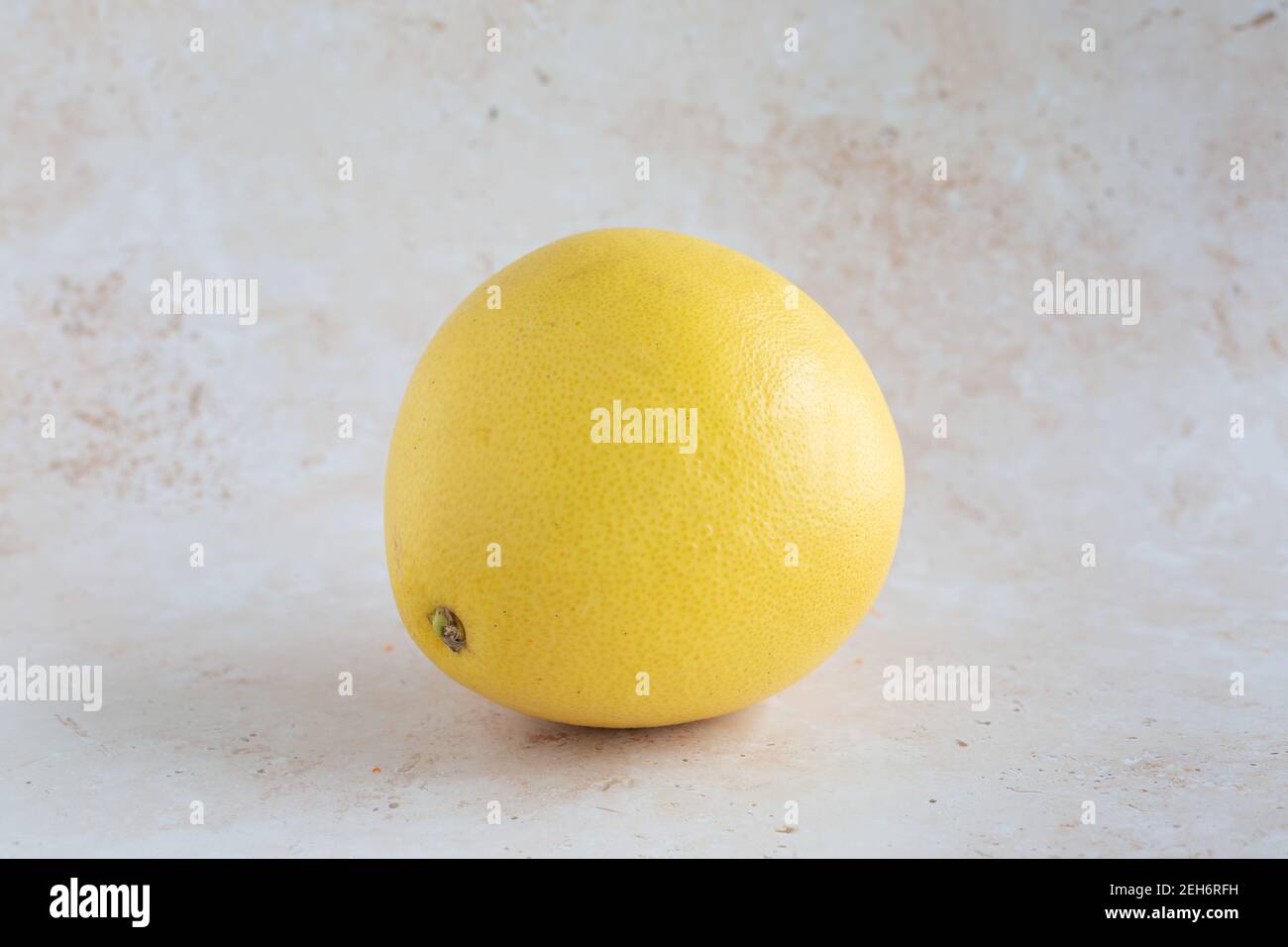 A single delicious yellow pomelo on neutral background, horizontal with ...
