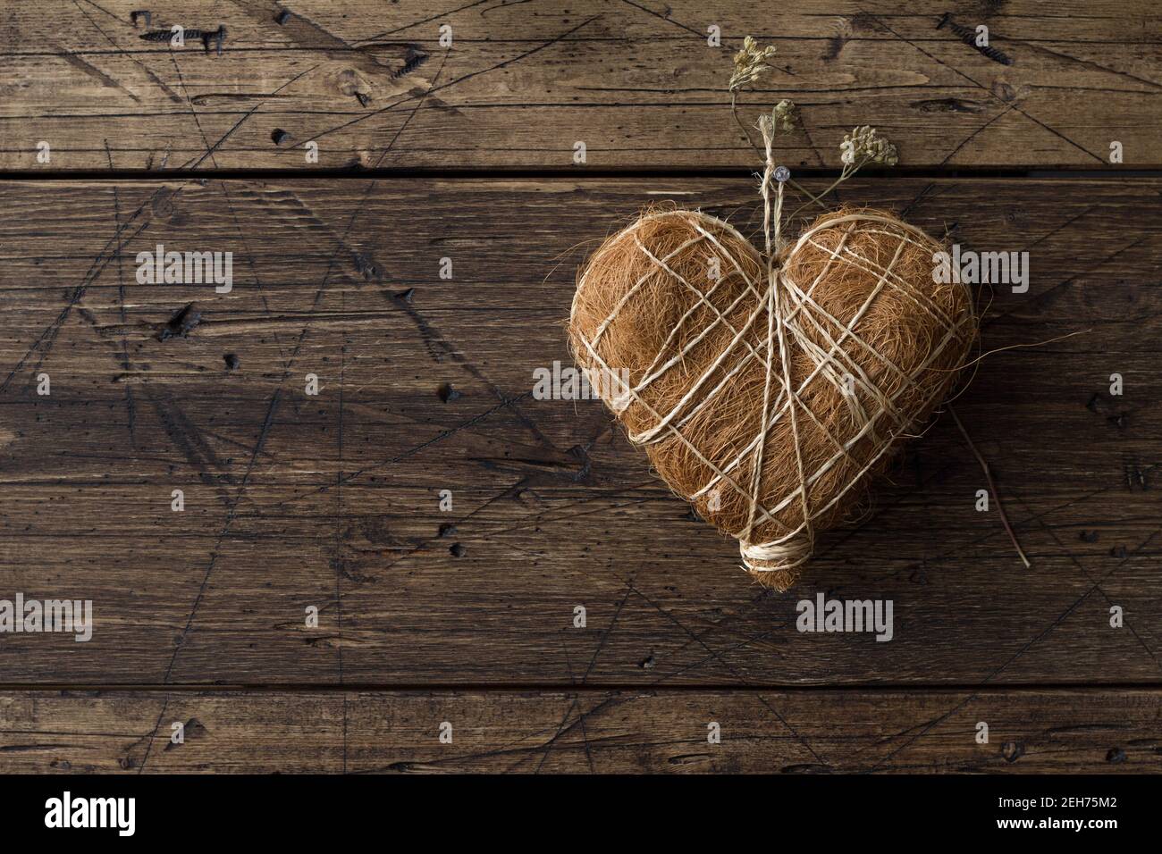 Straw heart hanging on a nail on a wooden wall, rustic style, space ...