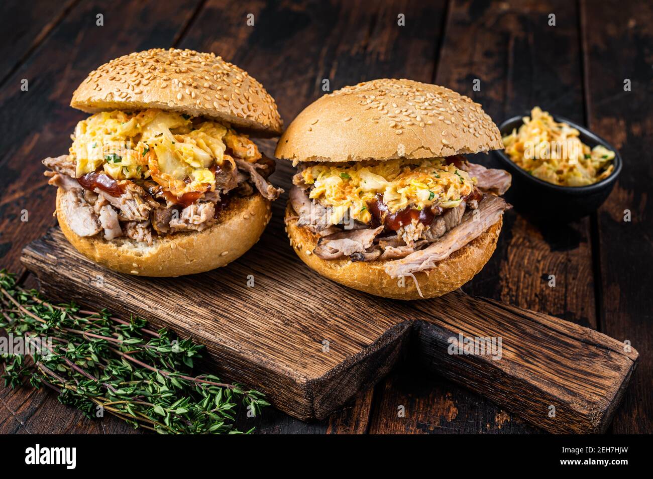 Pulled pork burger with bbq sauce and coleslaw salad. Dark wooden ...