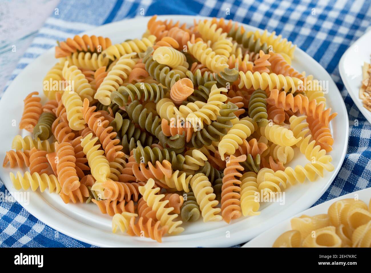 Colorful various raw fusilli on white plate Stock Photo - Alamy