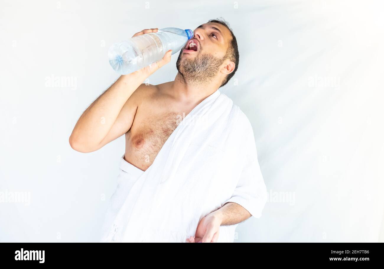 Muslim man drinking some water after finishing haj Stock Photo - Alamy