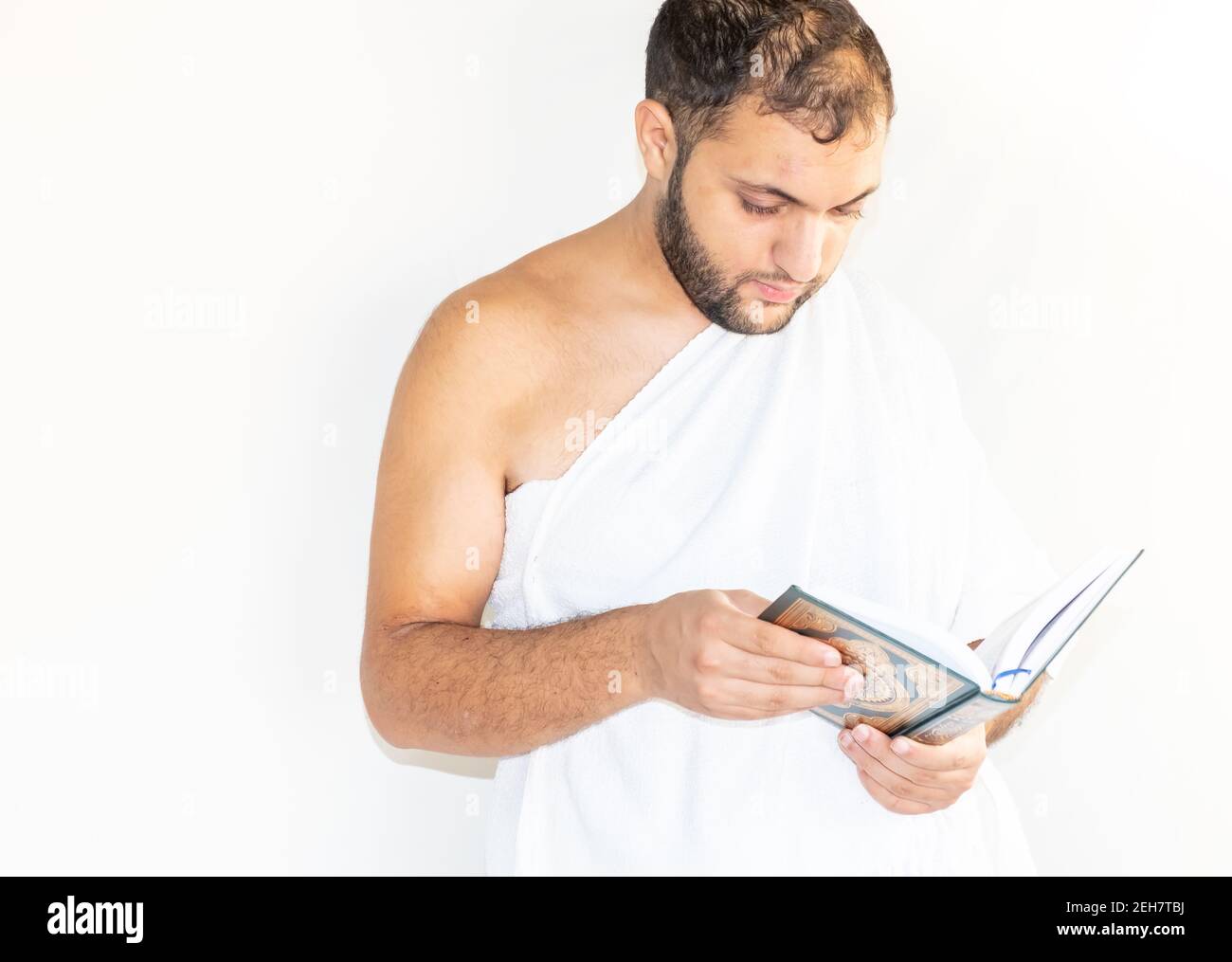 Muslim man wearing alhaj clothes and holding quraan Stock Photo - Alamy