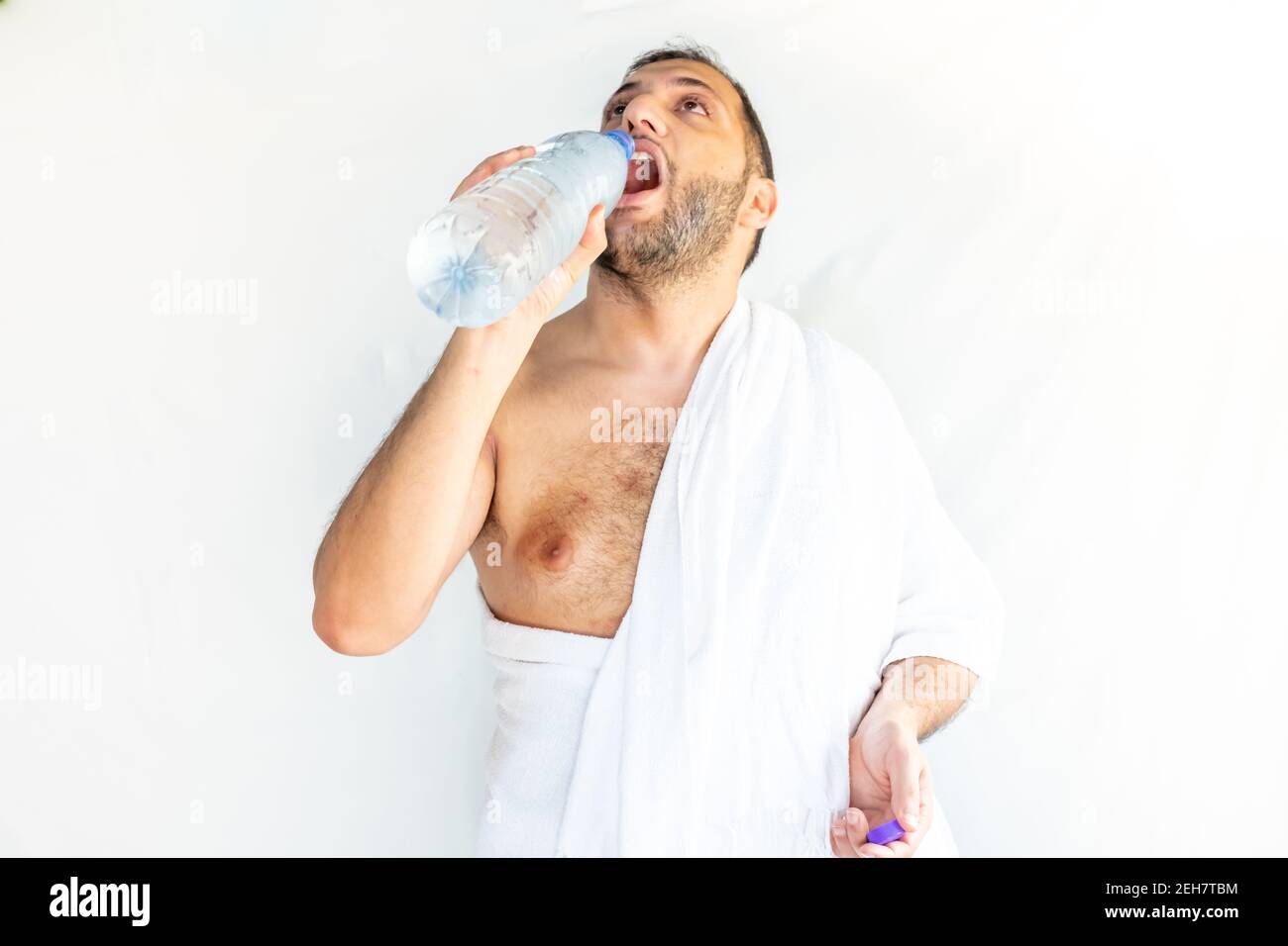 Muslim man drinking some water after finishing haj Stock Photo - Alamy