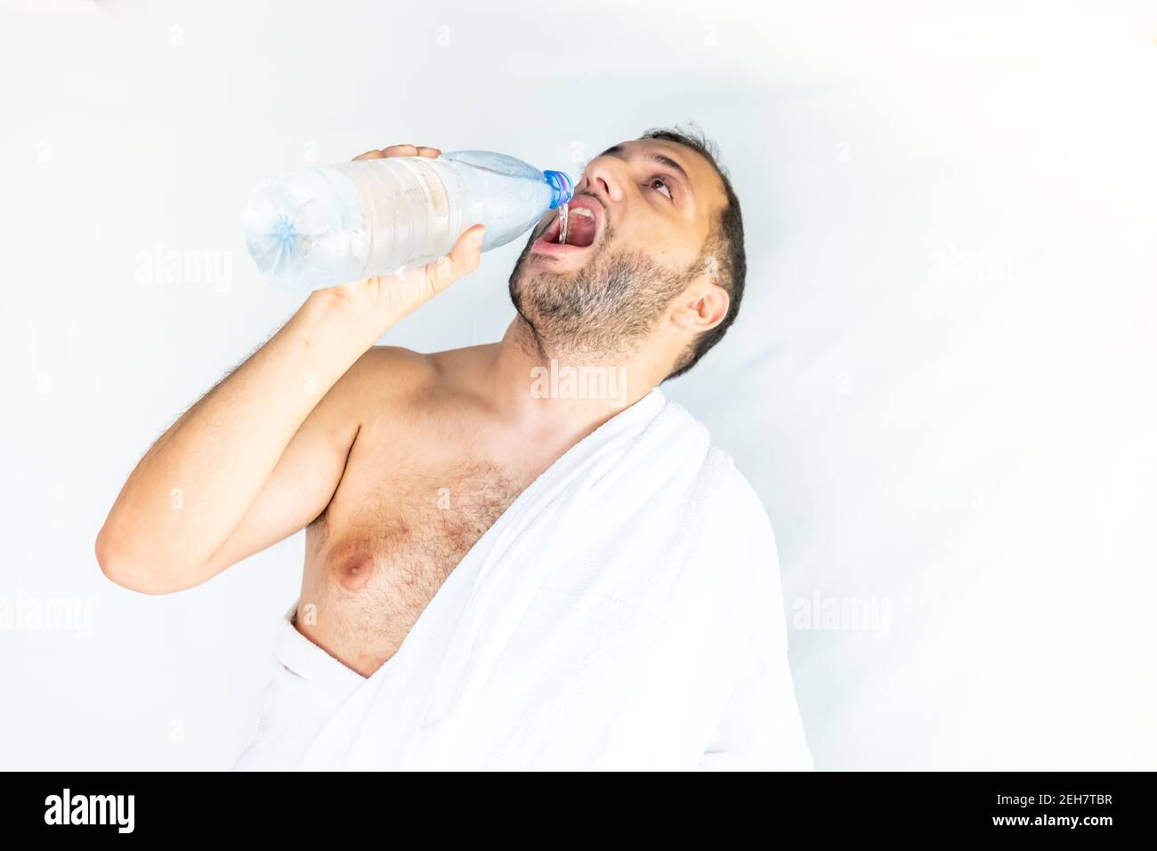 Muslim man drinking some water after finishing haj Stock Photo - Alamy