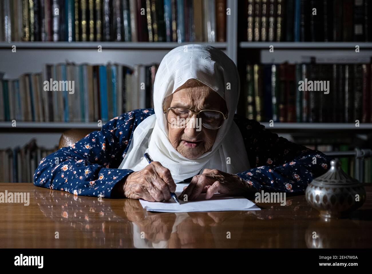 Old lady writing and reading some book at the morning light Stock Photo ...