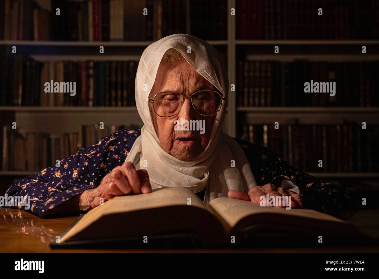 Old woman reading books in dark room with candles light Stock Photo - Alamy