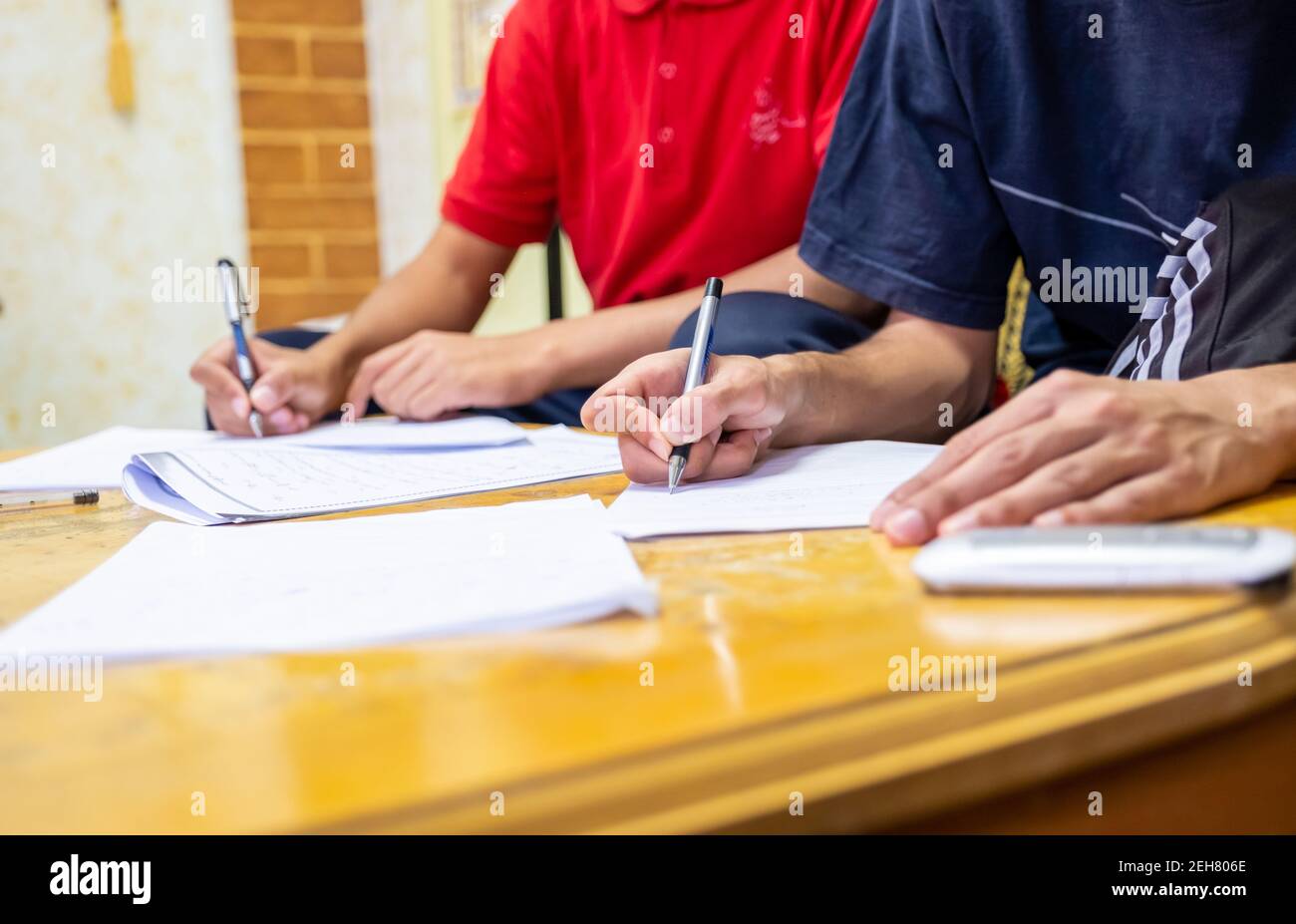 Two boys sitting together studying and writing their homework Stock ...