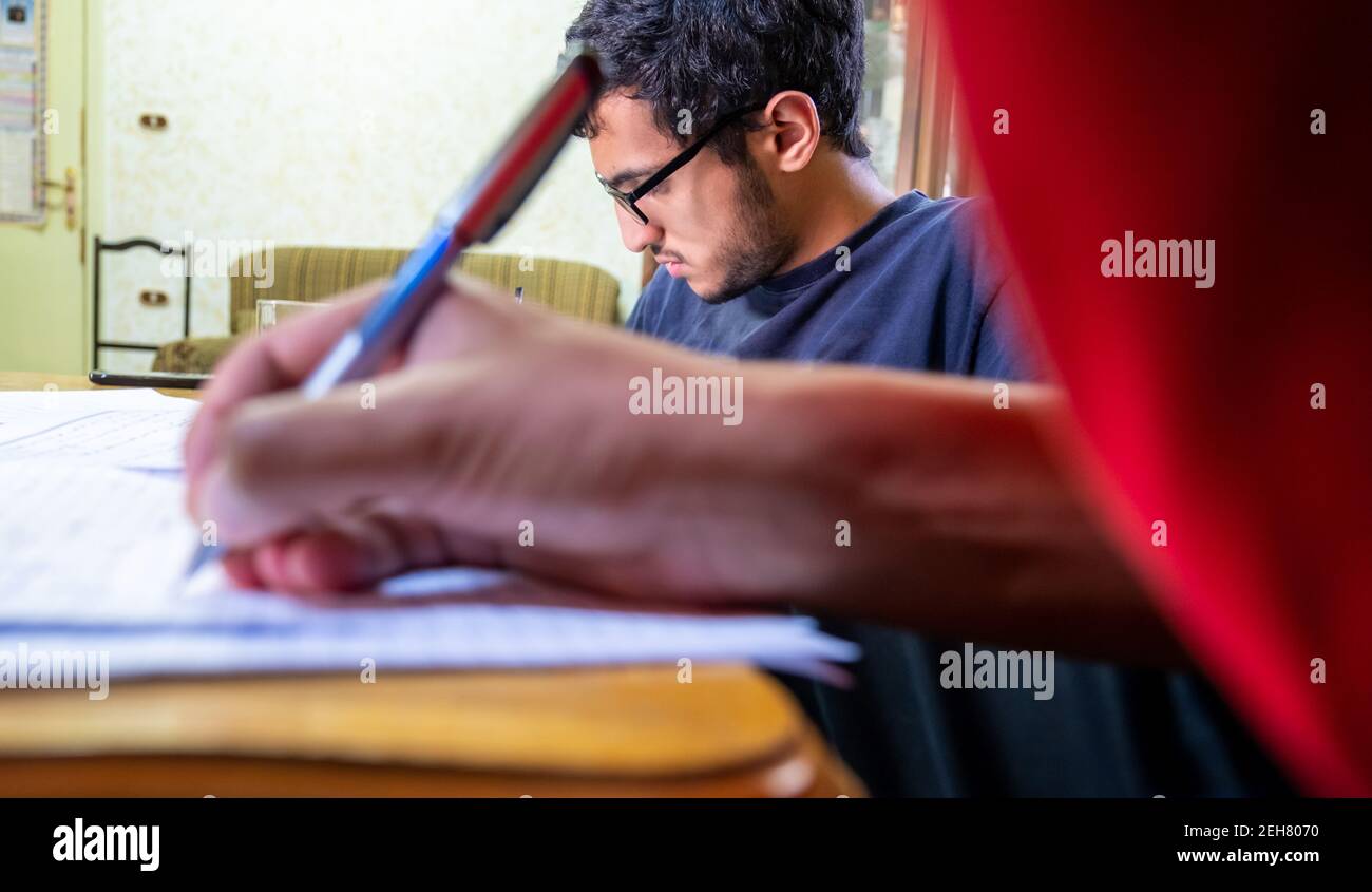 Two boys sitting together studying and writing their homework Stock ...