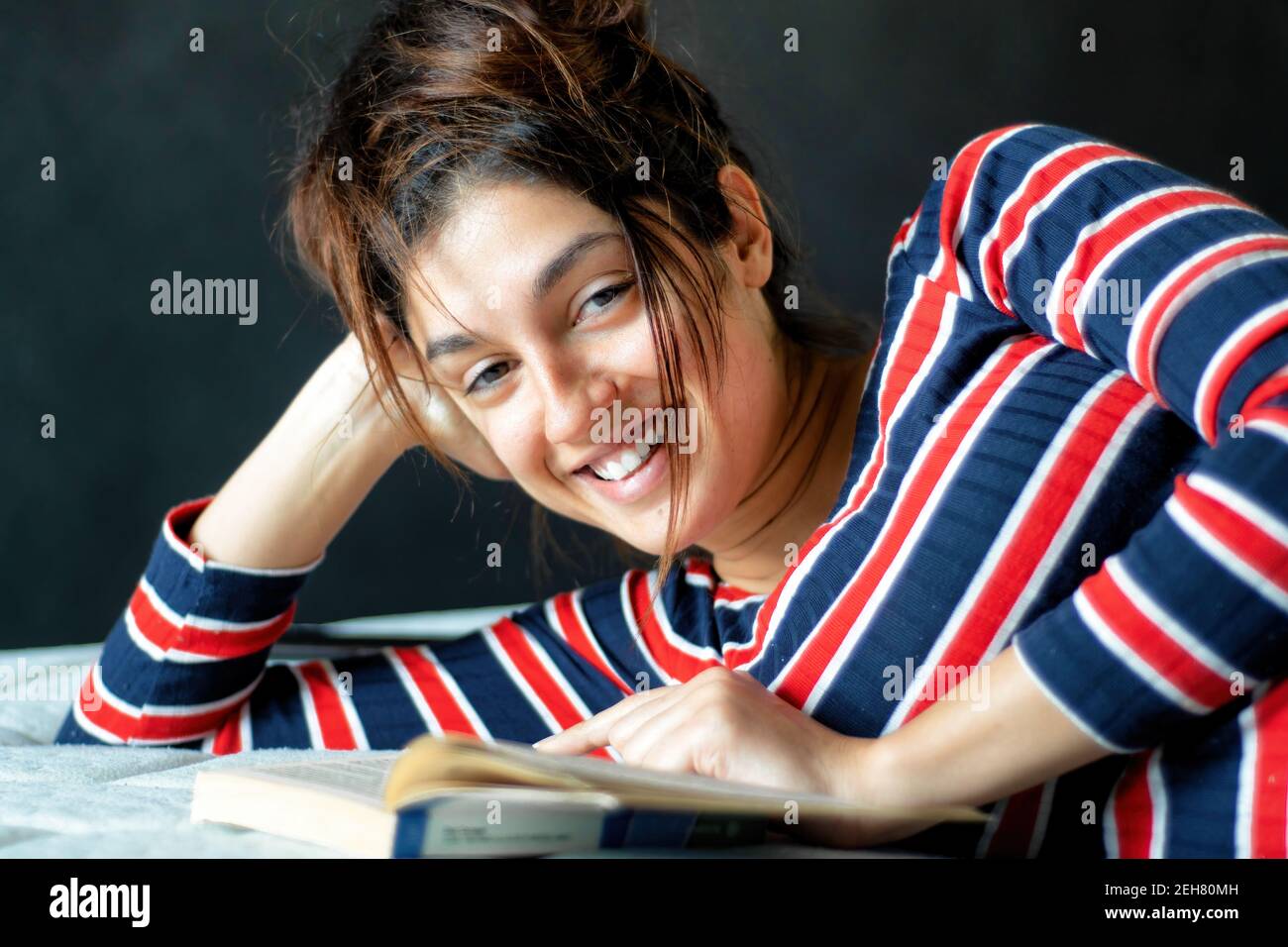 A beautiful girl happily reads a book. Perfect shot for beauty, reading ...