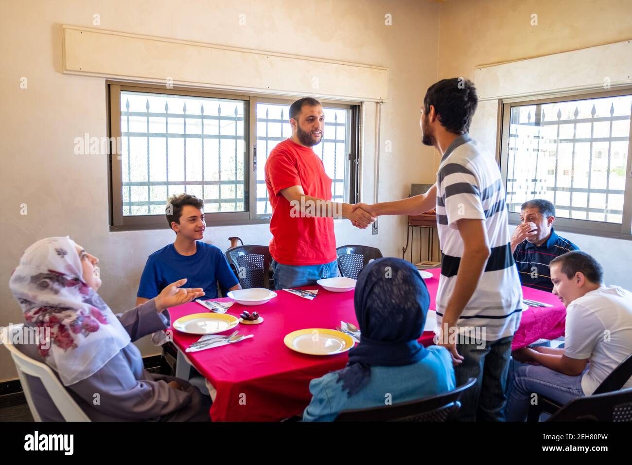 Arabic family greeting their guest and shaking his hand Stock Photo - Alamy