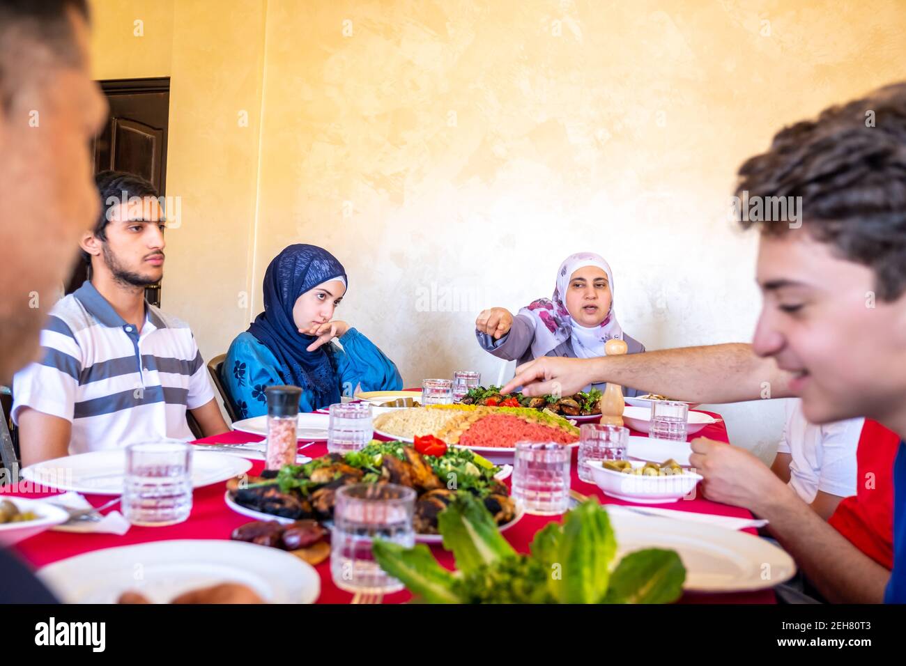 Happy arabic muslim family eating together in a family meeting for ...