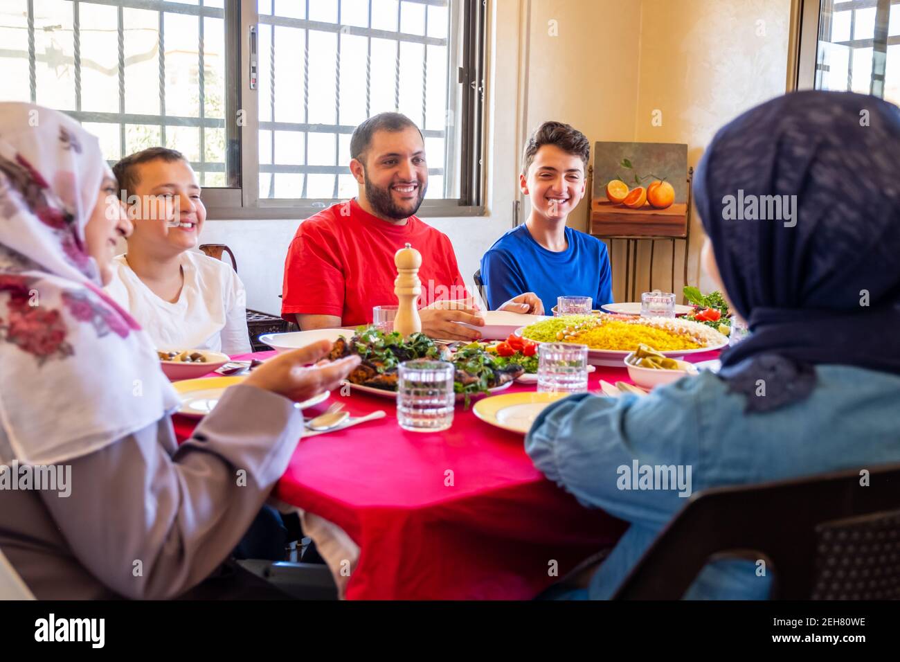 Happy arabic muslim family eating together in a family meeting for ...