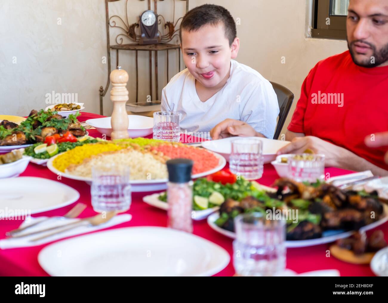 Happy arabic muslim family eating together in a family meeting for ...