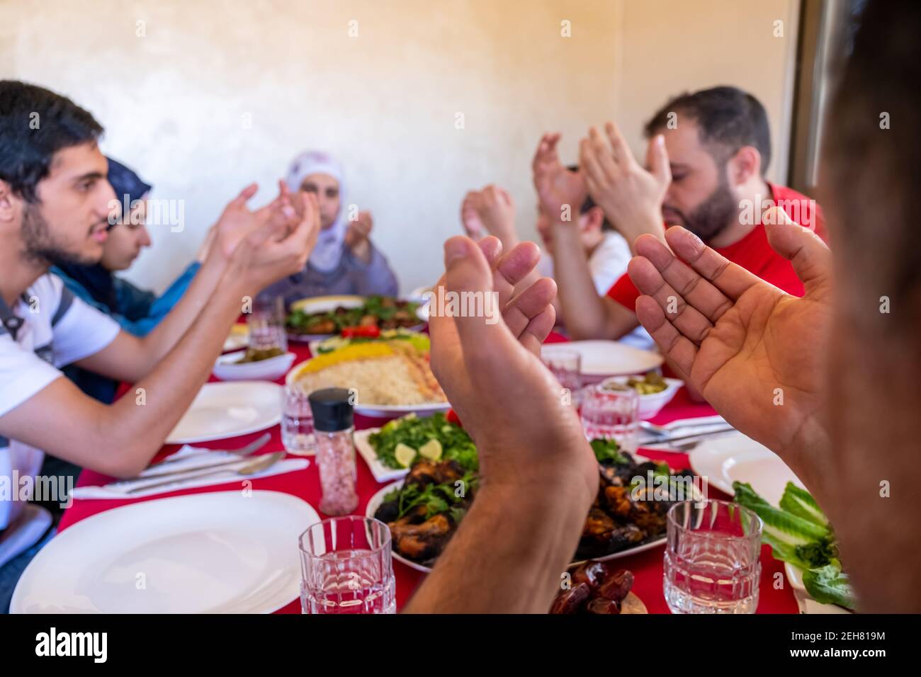 Arabic muslim family praying for god before eating iftar Stock Photo ...