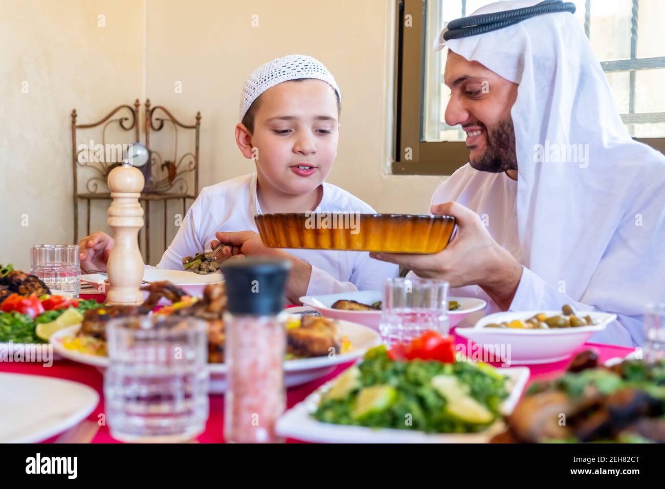 Happy arabic muslim family eating together in a family meeting for ...