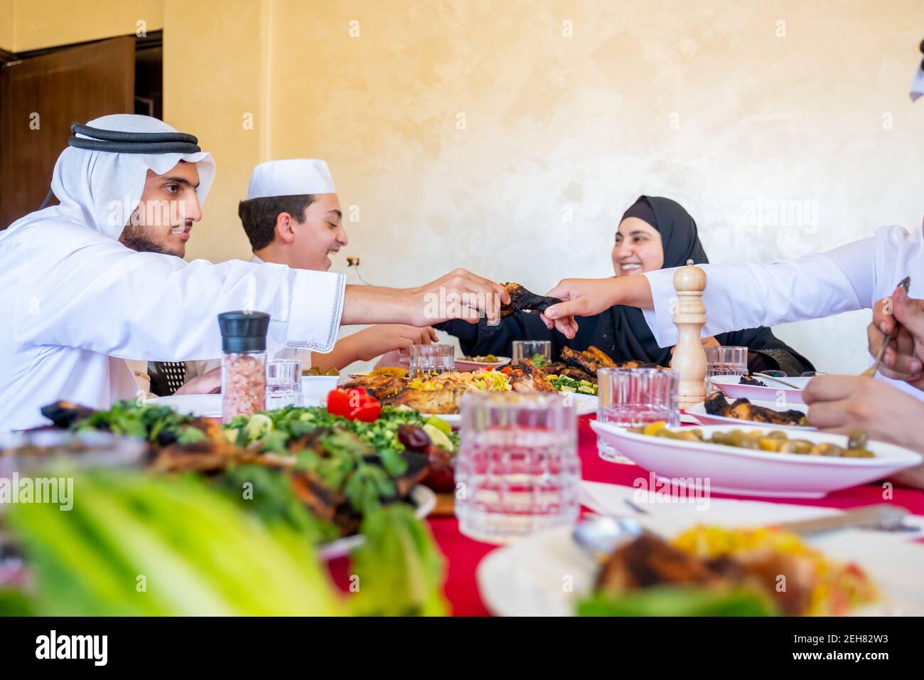 Happy arabic muslim family eating together in a family meeting for ...
