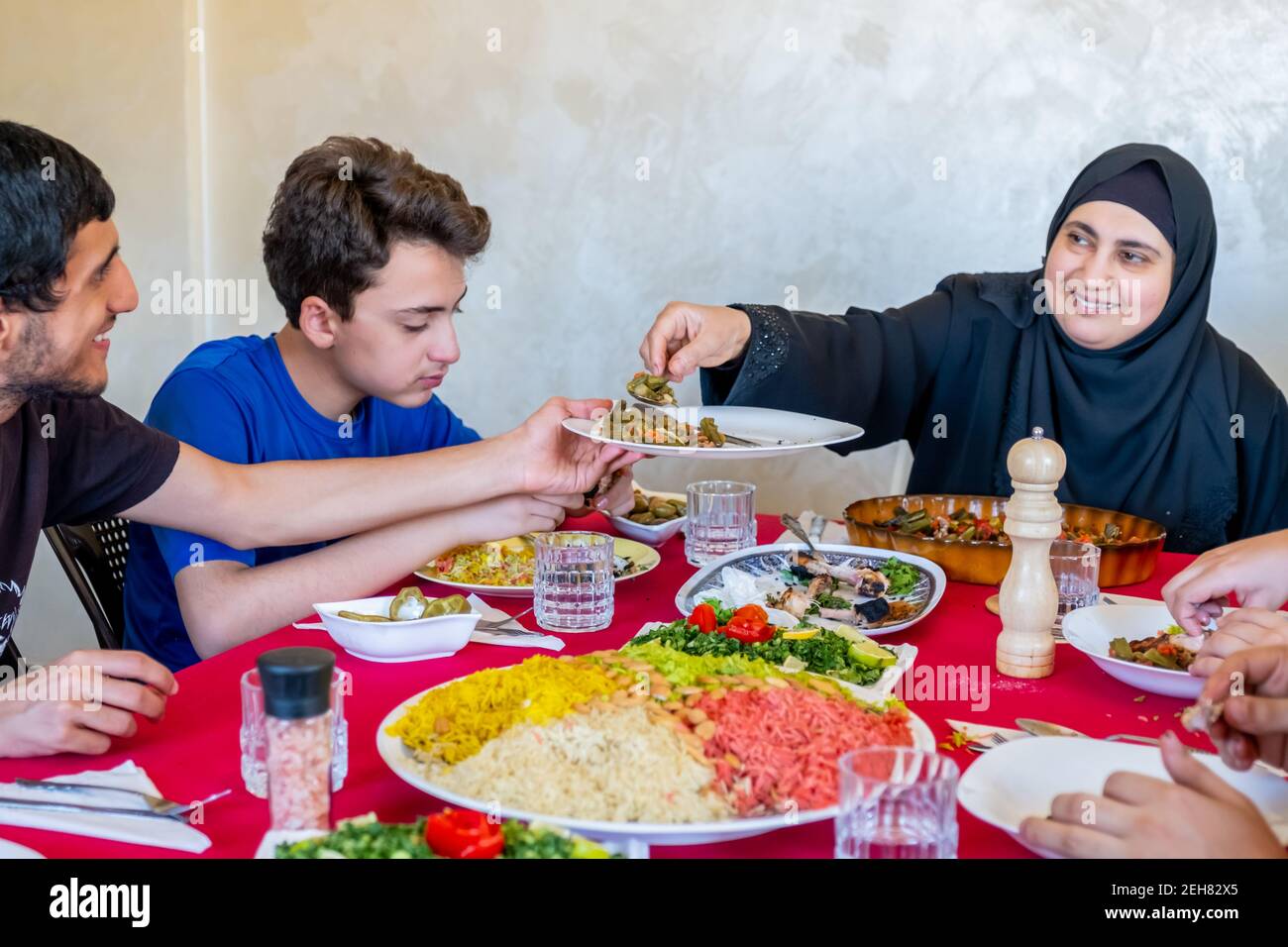 Happy arabic muslim family eating together in a family meeting for ...