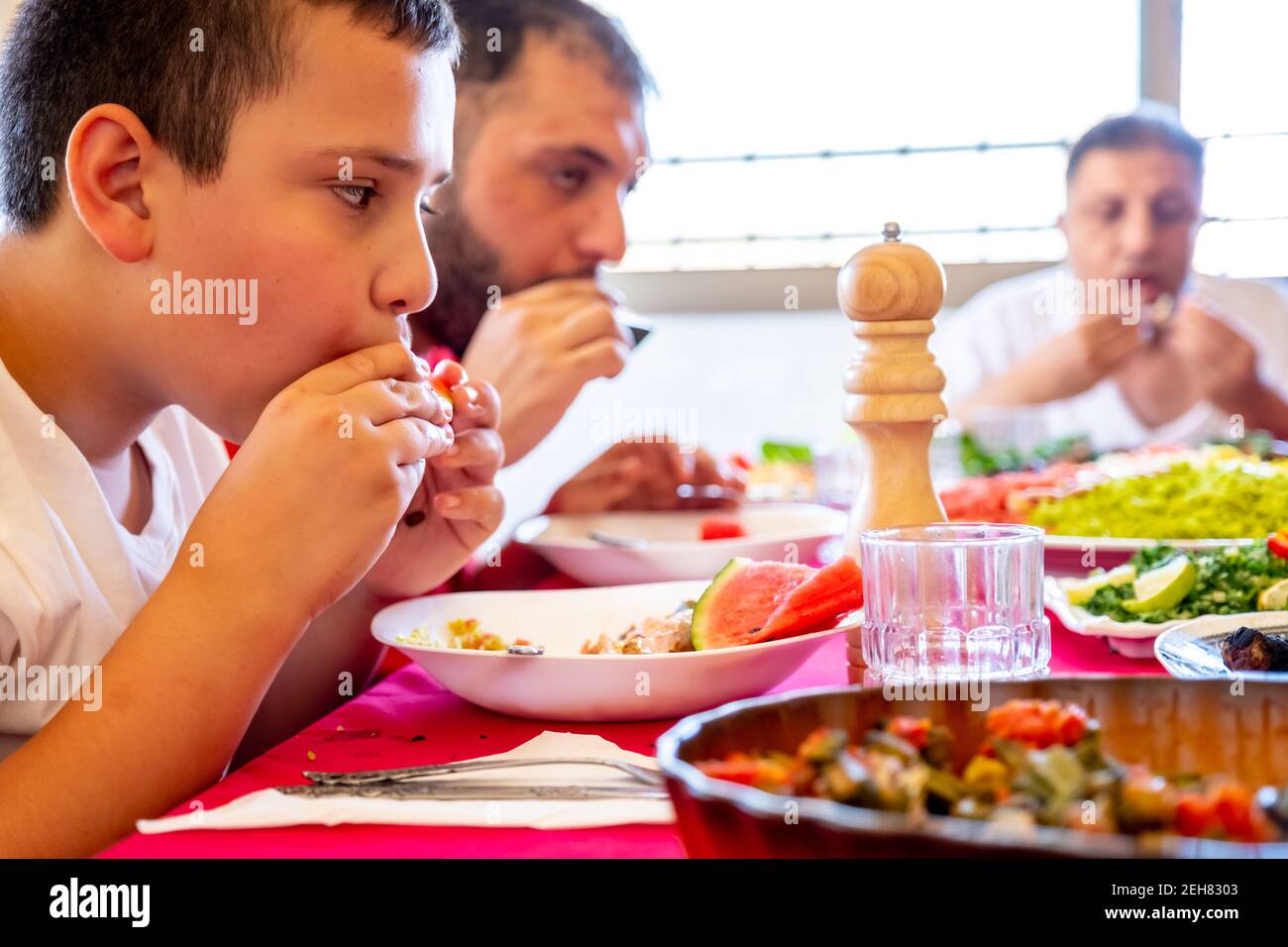 Happy arabic muslim family eating together in a family meeting for ...