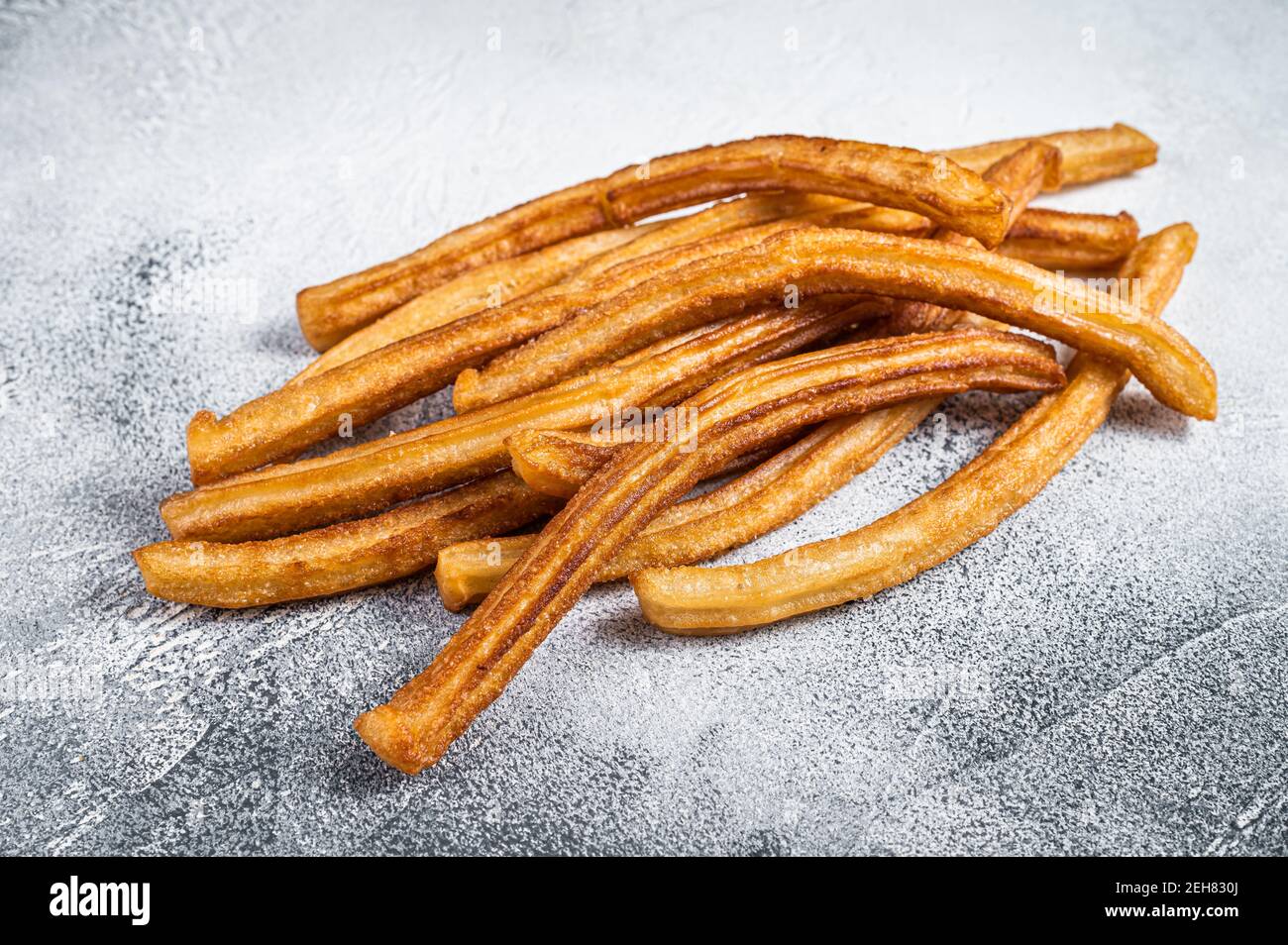 Churros fried sticks on kitchen table. White background. Top view Stock ...